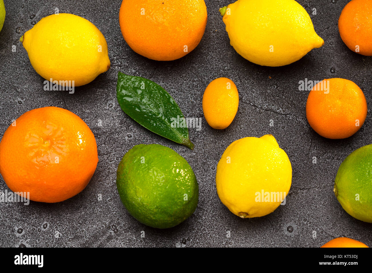 close up view of fresh whole citrus fruits and leaf on black Stock ...