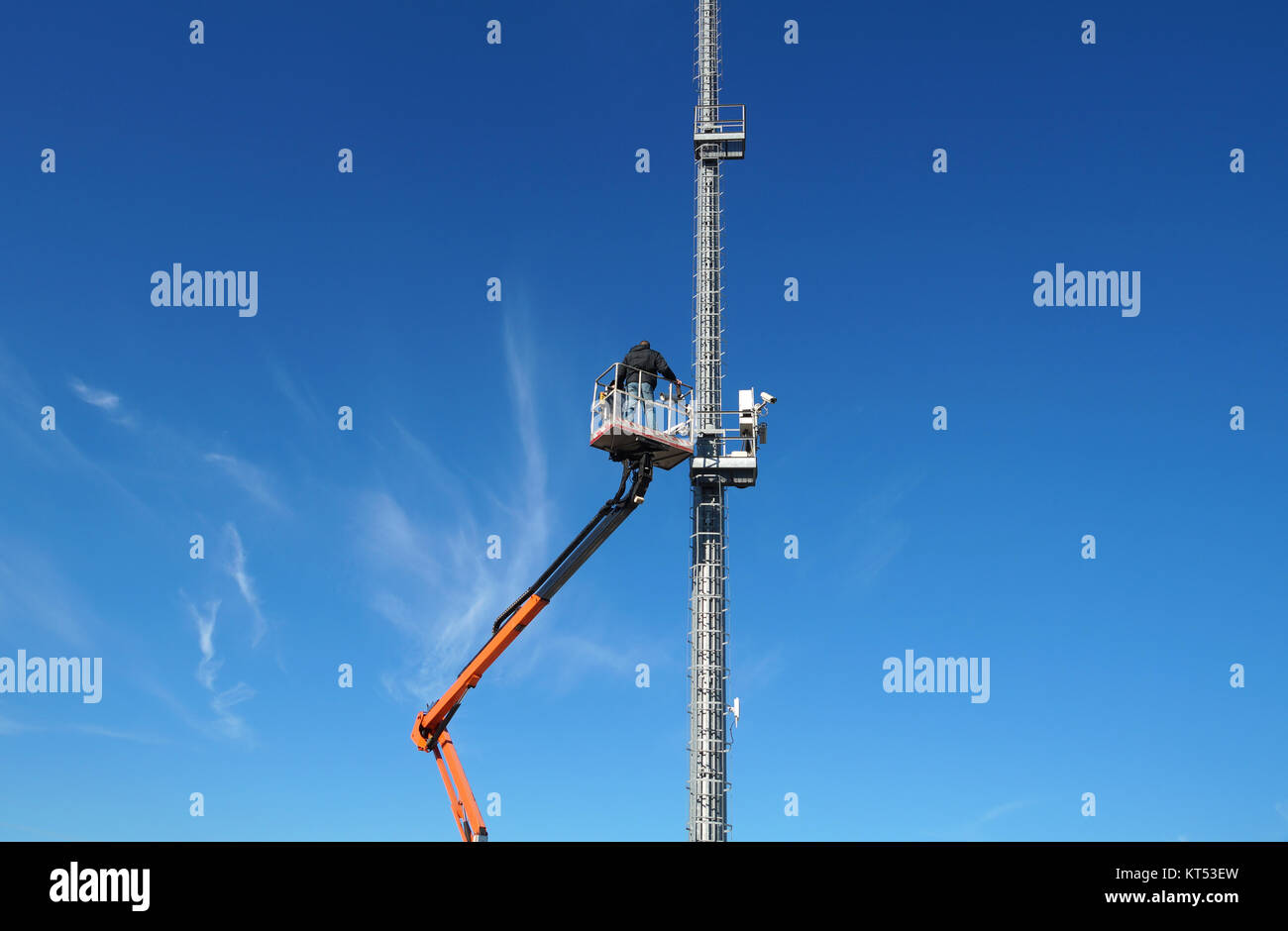 Hydraulic mobile construction platform elevated towards a blue sky with ...
