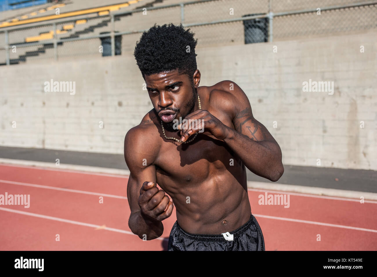 Muscular Jamaican boxer in defensive stance while shadowboxing on ...