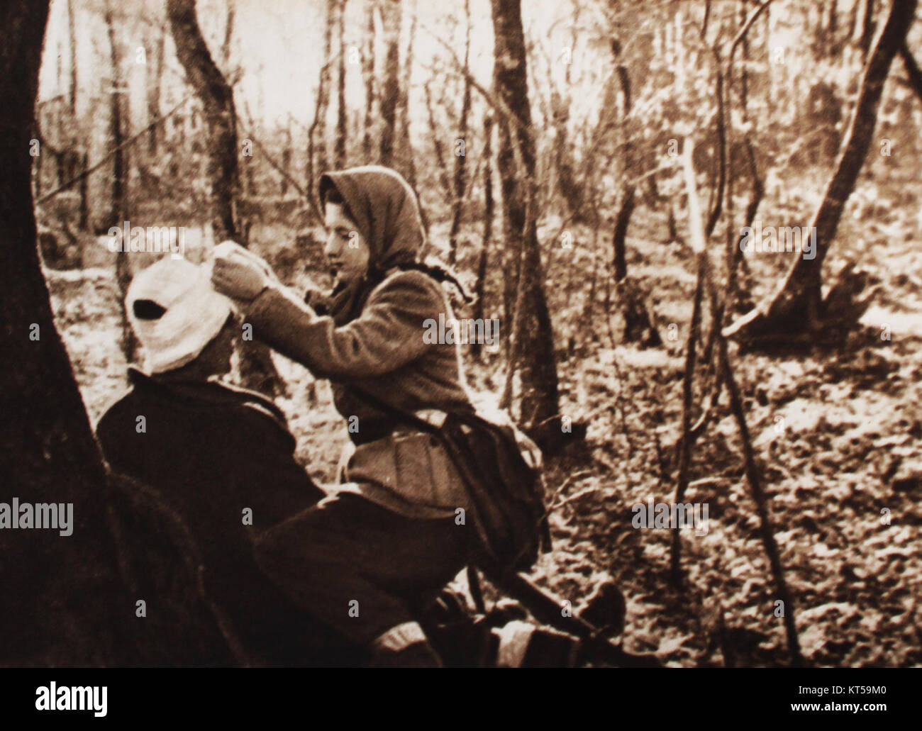 This image depicts a partisan woman tending to a wounded comrade during ...
