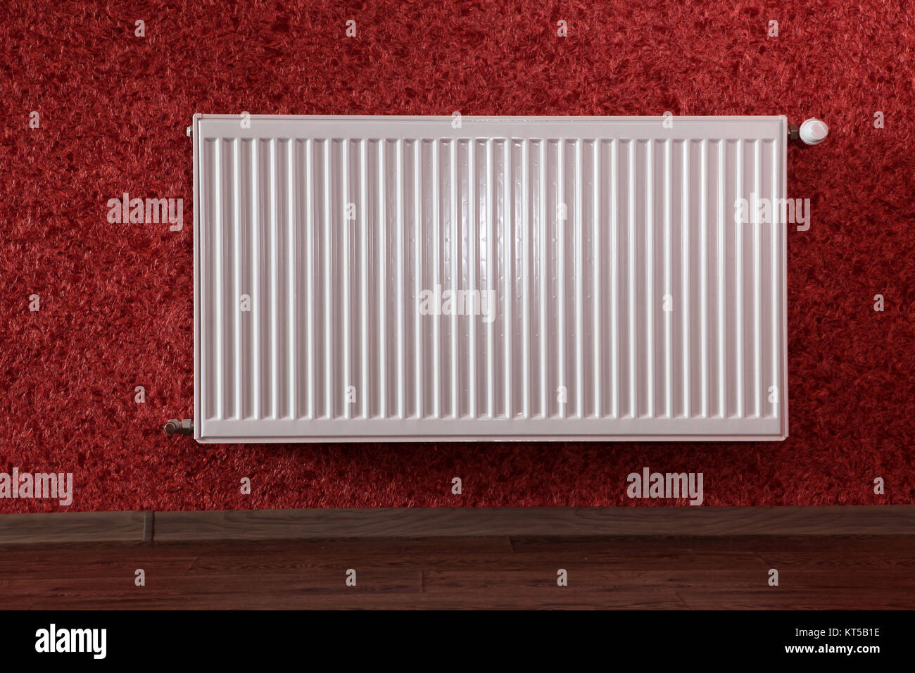 white heating radiator under in red room Stock Photo - Alamy