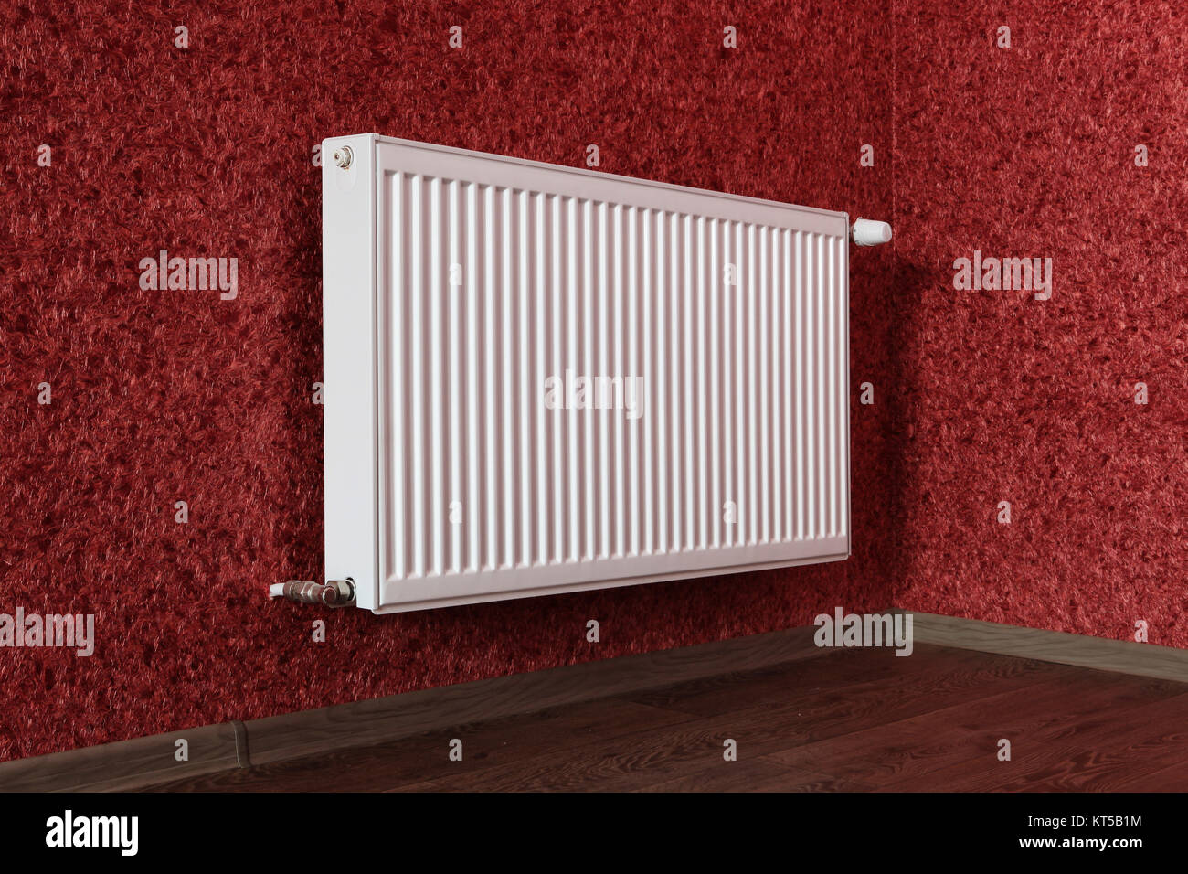white heating radiator under in red room Stock Photo - Alamy