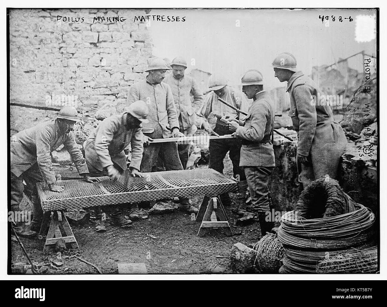 This photograph depicts French soldiers (Poilus) during World War I, making mattresses ...