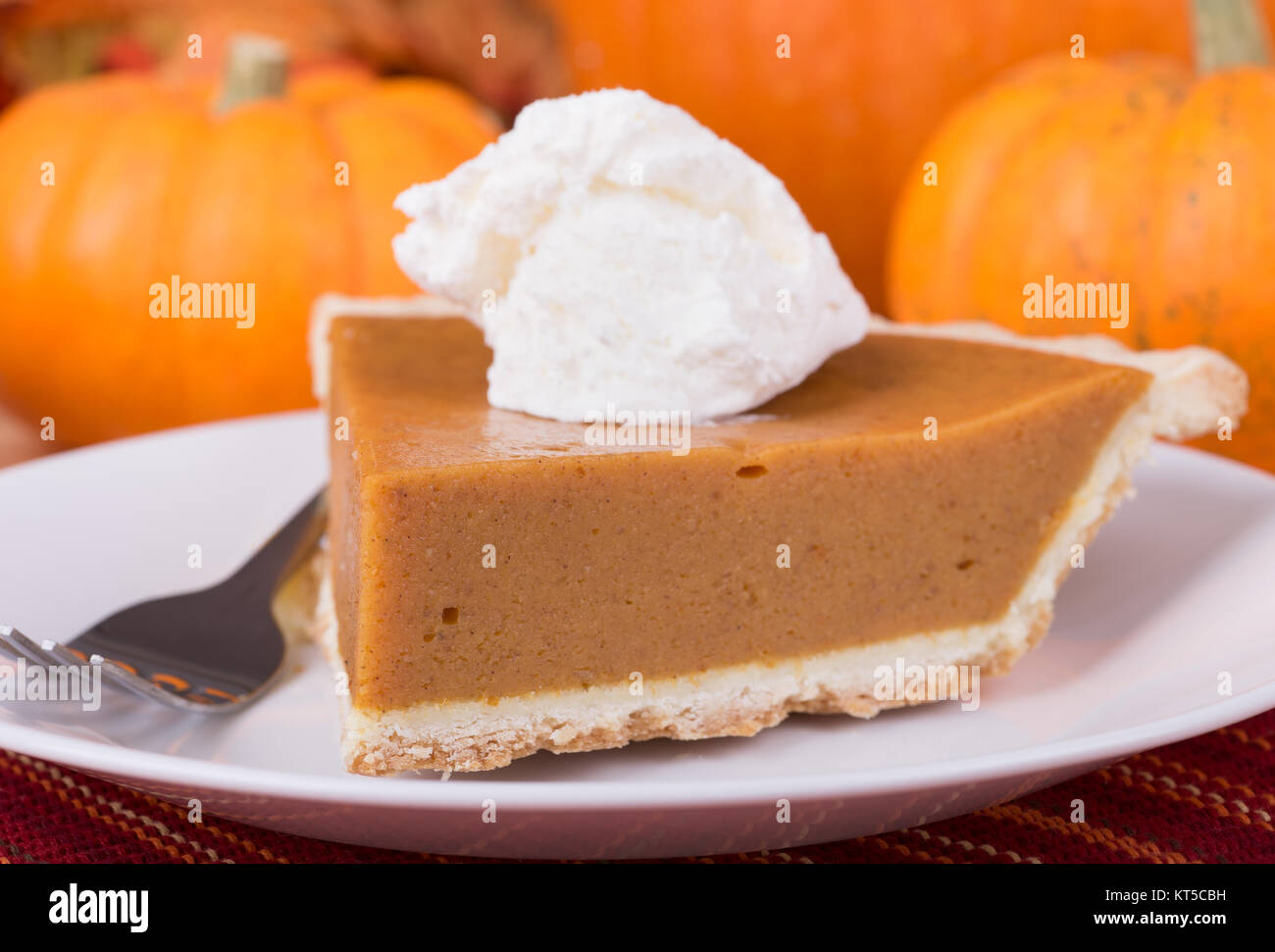 Closeup of a slice of pumpkin pie with pumpkins in background Stock ...