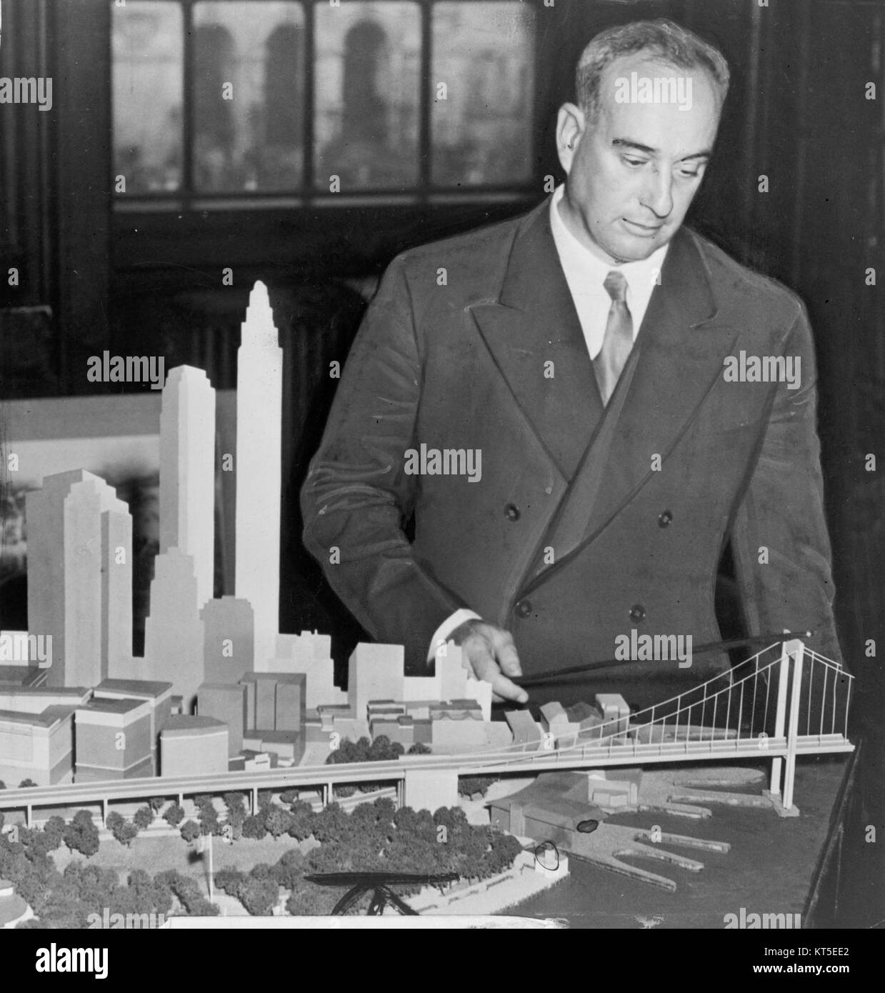 Robert Moses, a prominent urban planner, is depicted with a model of ...