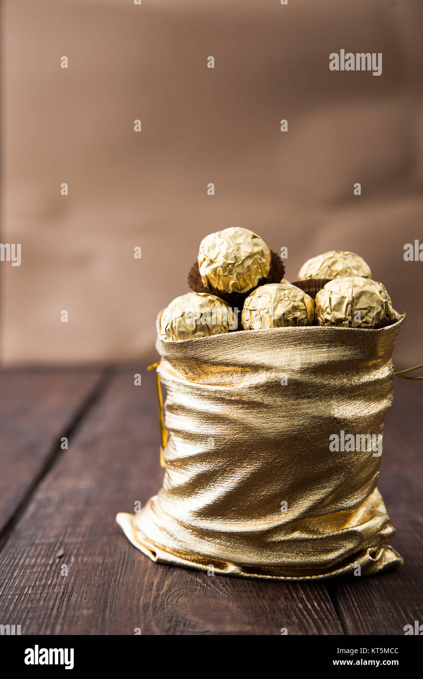 gold bag of chocolates. candy in Golden foil with copy space Stock ...