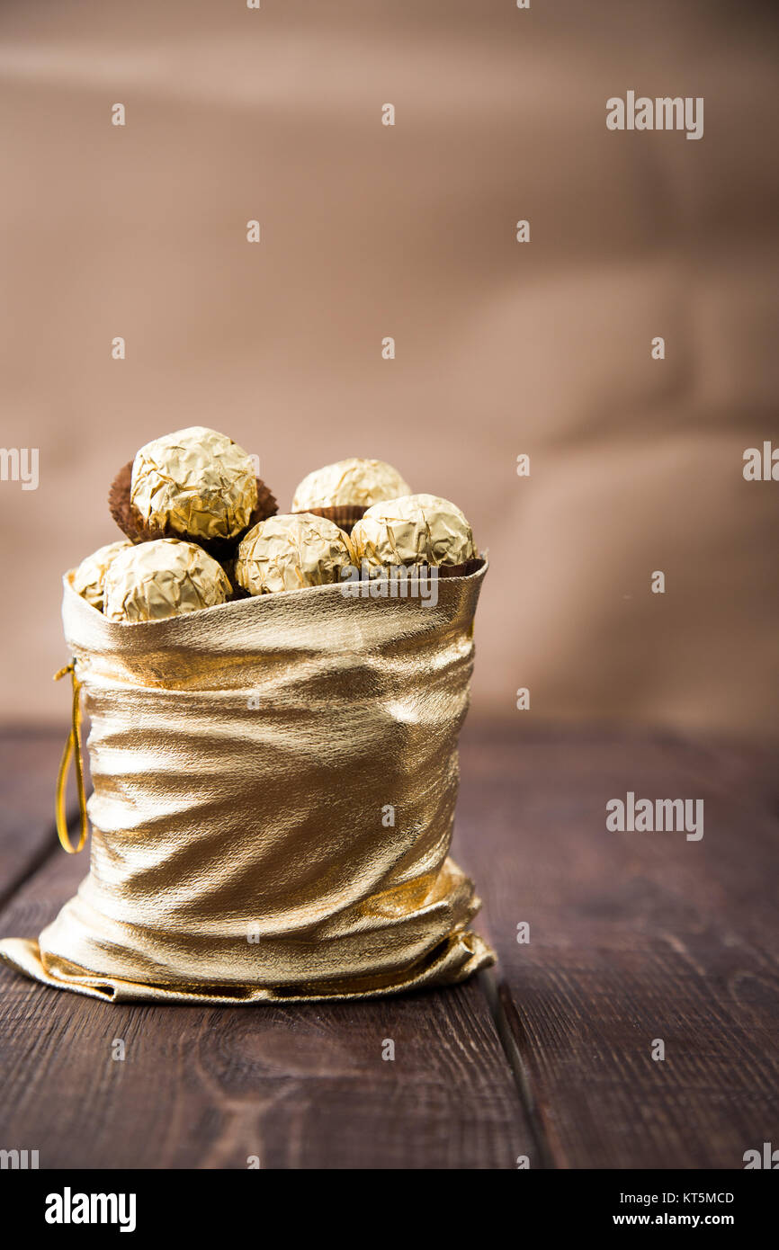 gold bag of chocolates. candy in Golden foil with copy space Stock ...