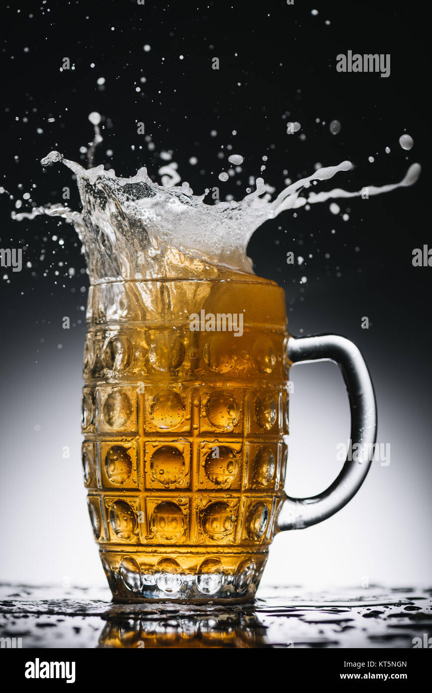 splashes of cold light beer in mug Stock Photo - Alamy