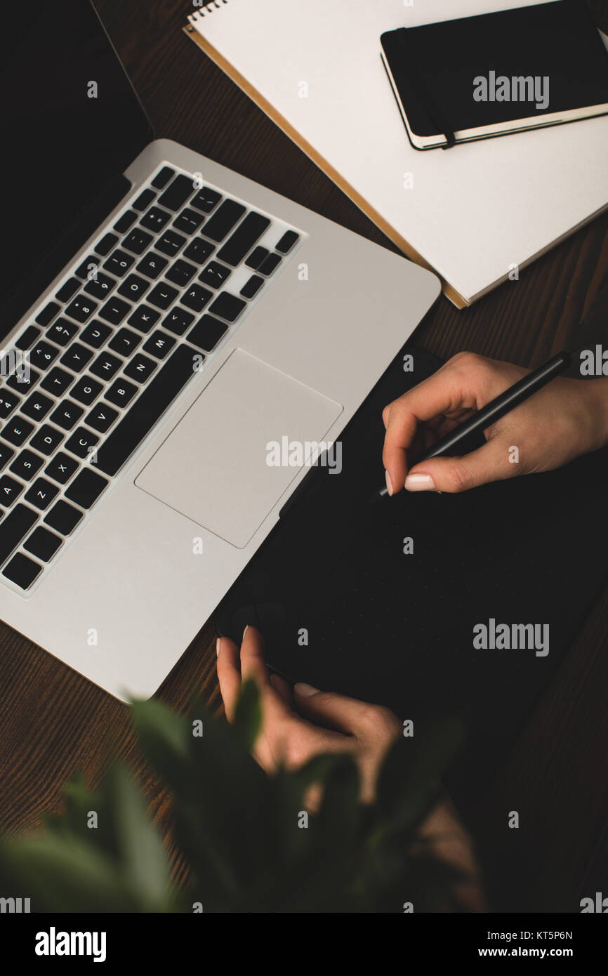 selective focus of person using laptop and graphics tablet at workplace ...