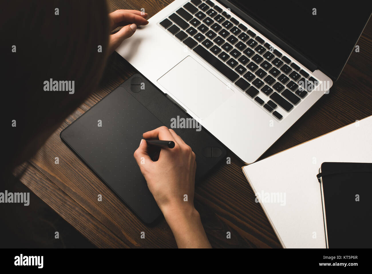 cropped shot of person using laptop and graphics tablet Stock Photo - Alamy