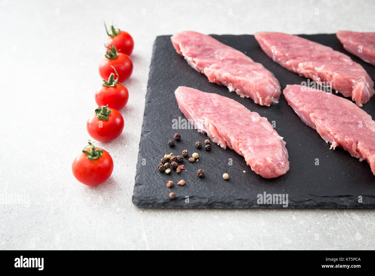 raw pork meat on a slate Board, on a stone background Stock Photo - Alamy