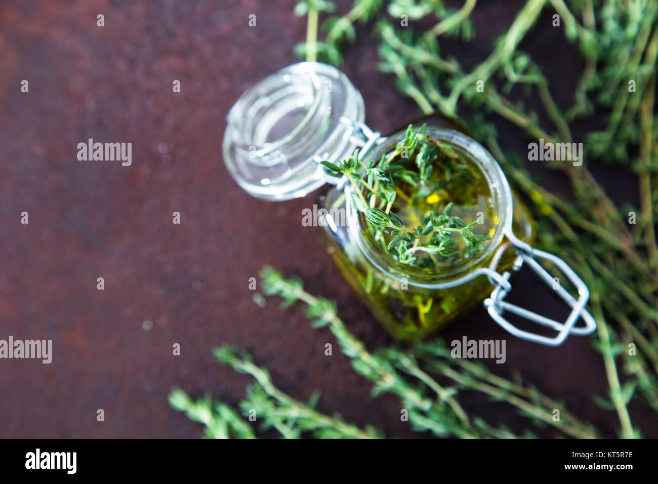 Thyme oil. Thyme essential oil jar glass bottle and branches of plant ...