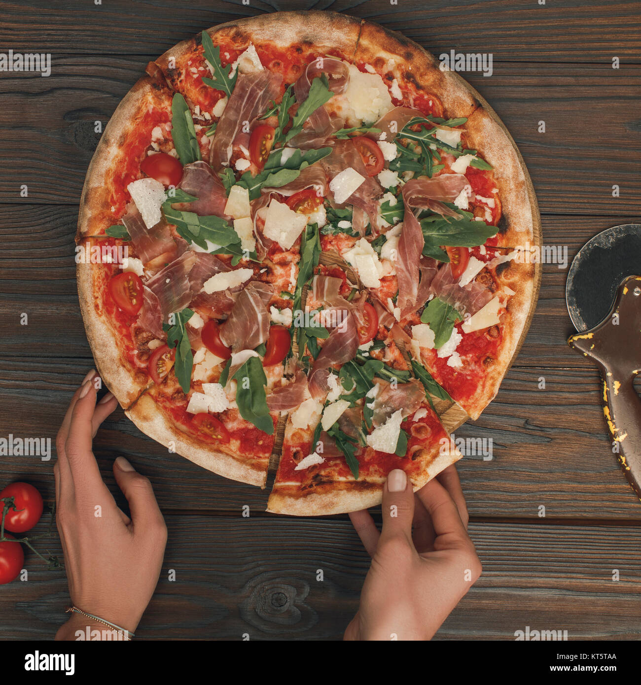 partial view of woman holding piece of italian pizza Stock Photo - Alamy