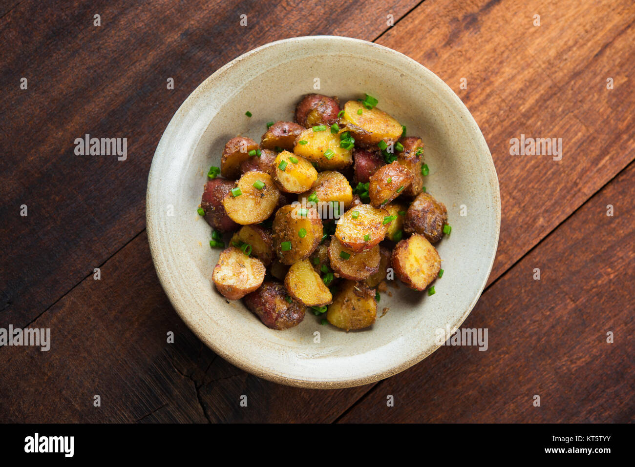 Oven roasted potatoes on wood table top view Stock Photo - Alamy
