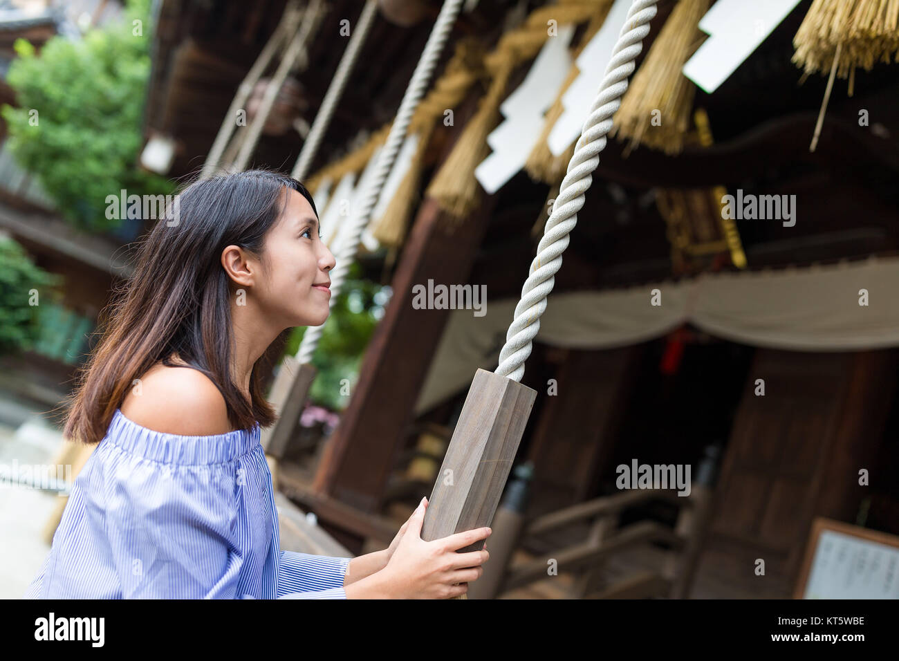 Woman holding the rope in Japanese temple Stock Photo - Alamy