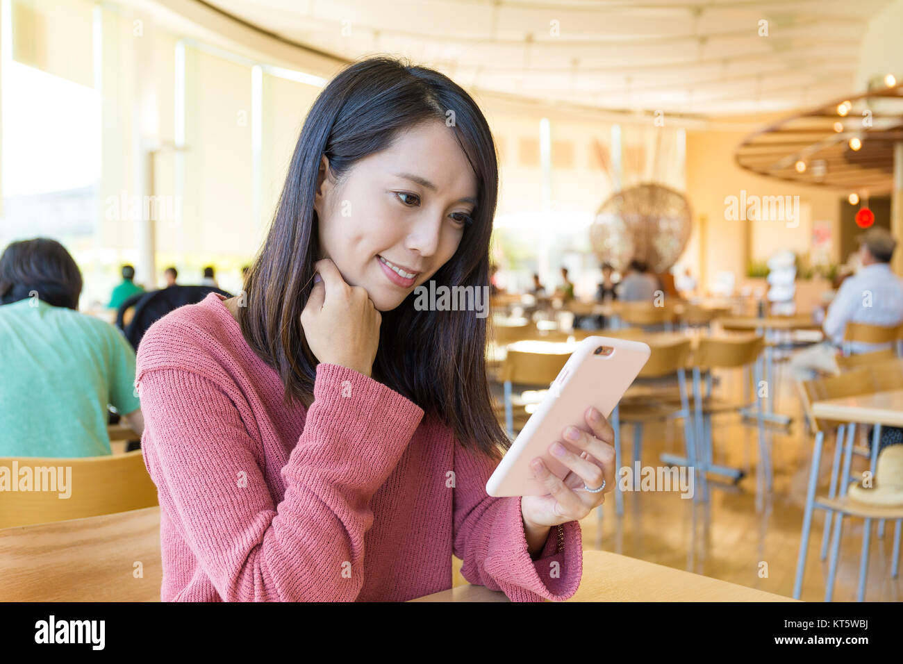 Woman using cellphone in restaurant Stock Photo - Alamy
