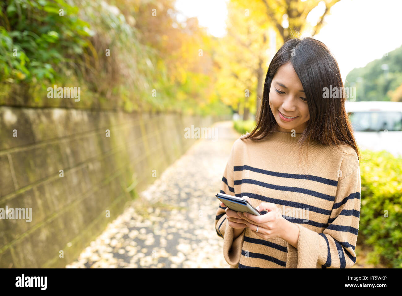 Woman using mobile phone at outdoor park Stock Photo - Alamy