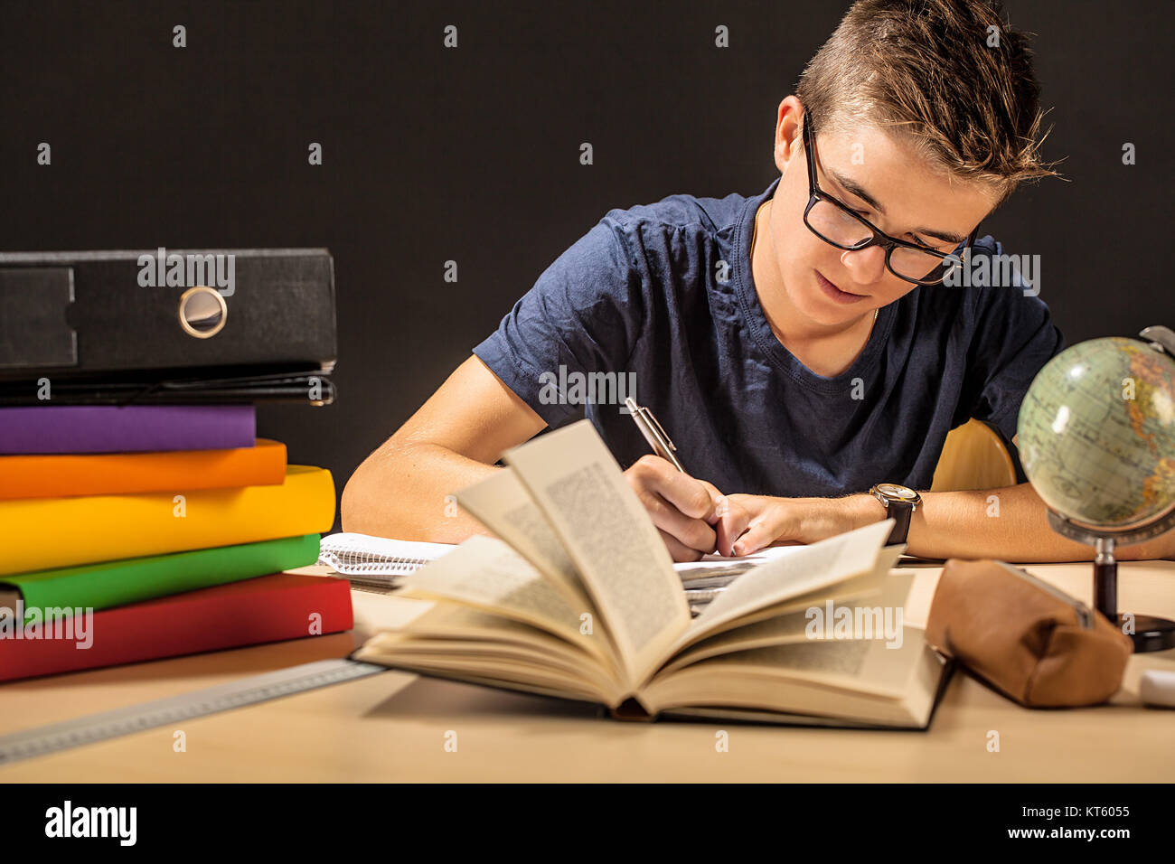Student doing homework in dark room Stock Photo - Alamy