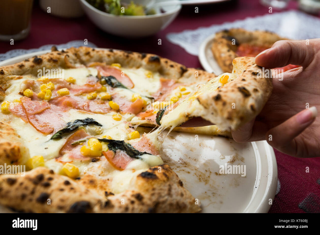 Hand taking out sliced of pizza Stock Photo - Alamy