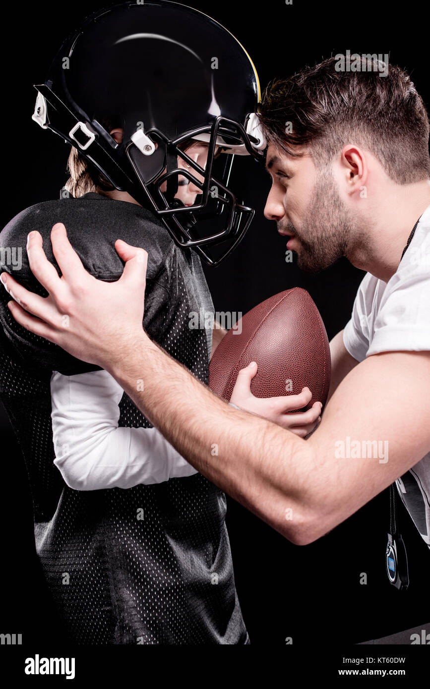 Side view of trainer instructing boy american football player Stock ...