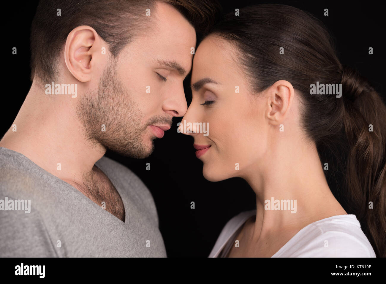 side view of couple in love bonding to each other on black Stock Photo ...