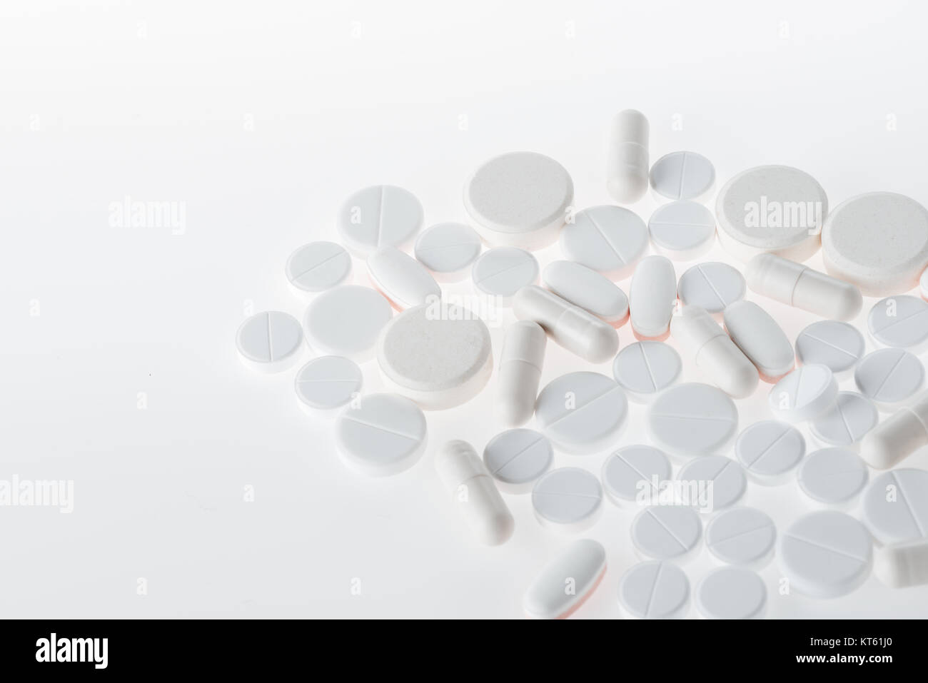 Assortment of white medical tablets and capsules, medicine and ...