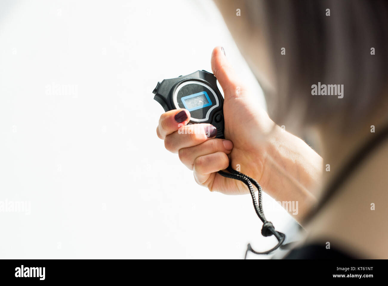 back view of sporty woman holding stopwatch in hand Stock Photo - Alamy