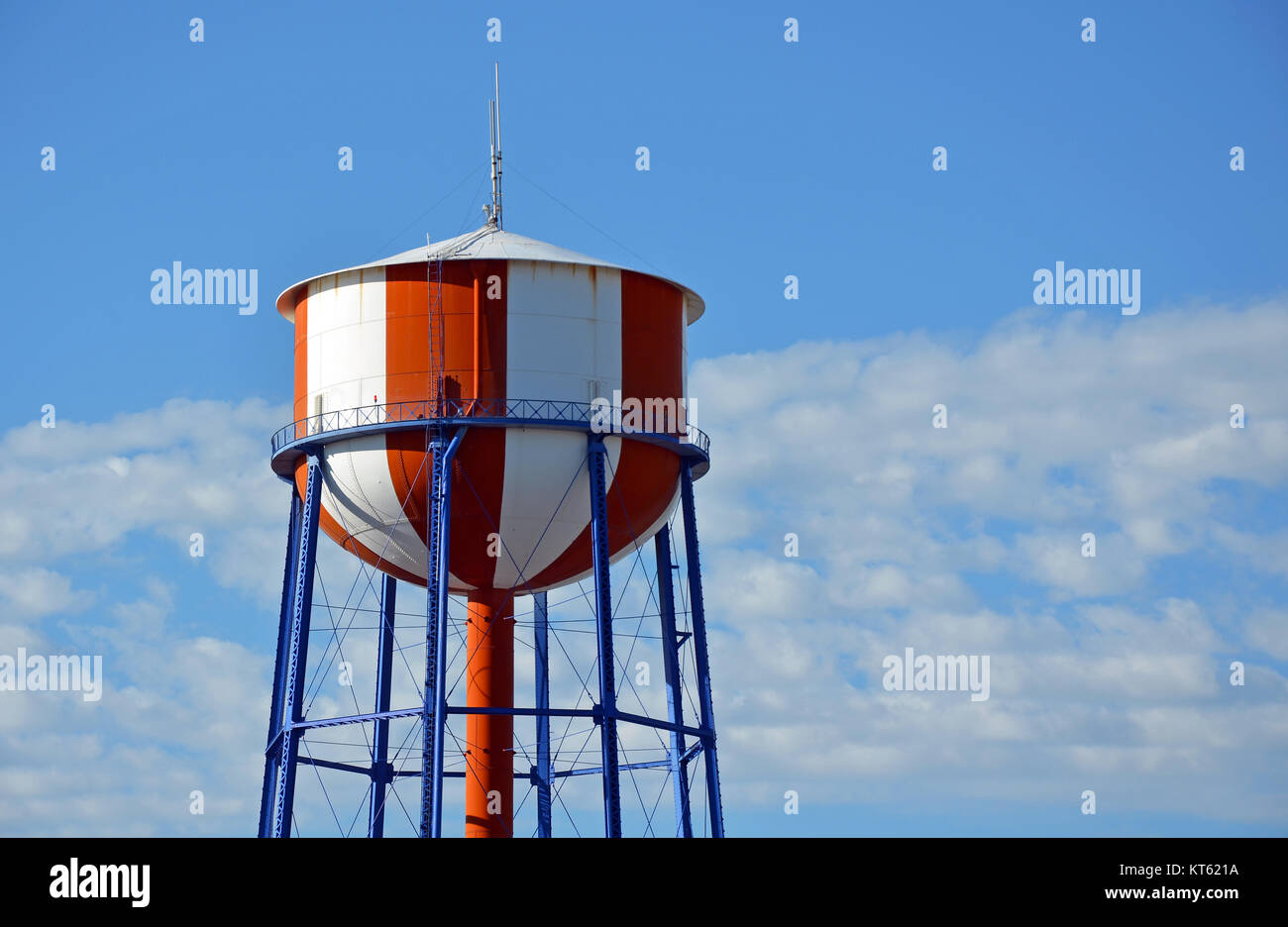 Red and white striped water tower against blue sky Stock Photo - Alamy