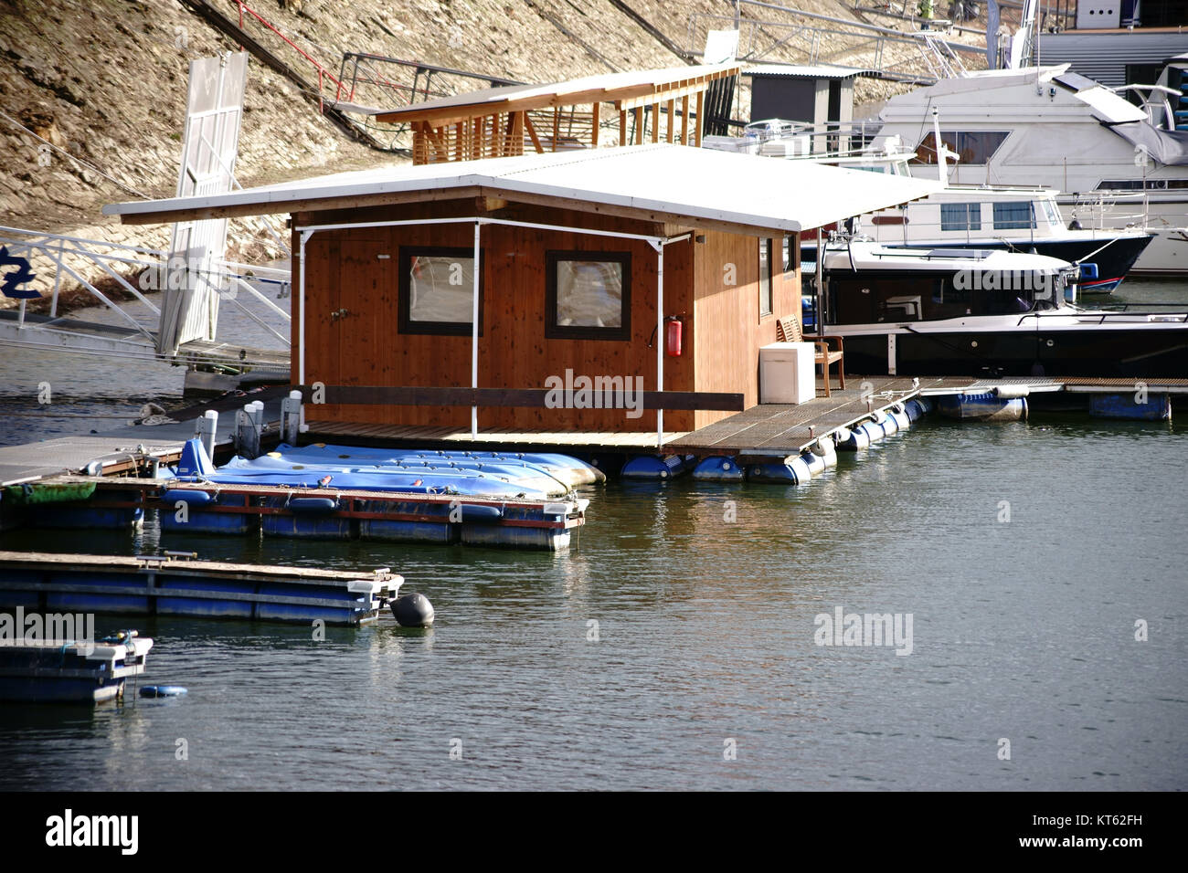 Ein kleines Hausboot aus Holz sowie Yachten und Motorboote ankern in ...
