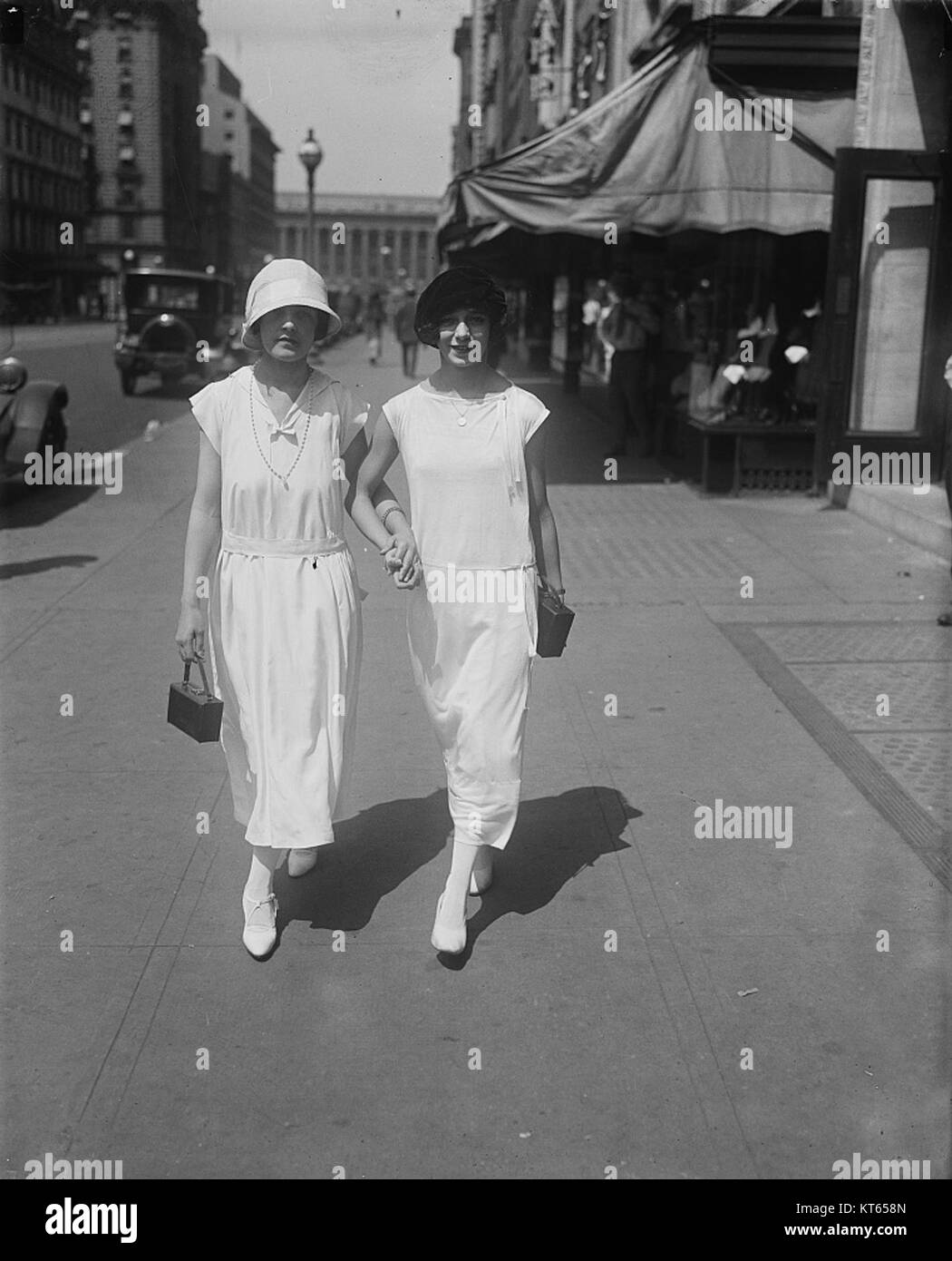 This photograph captures a street scene featuring young women, possibly ...