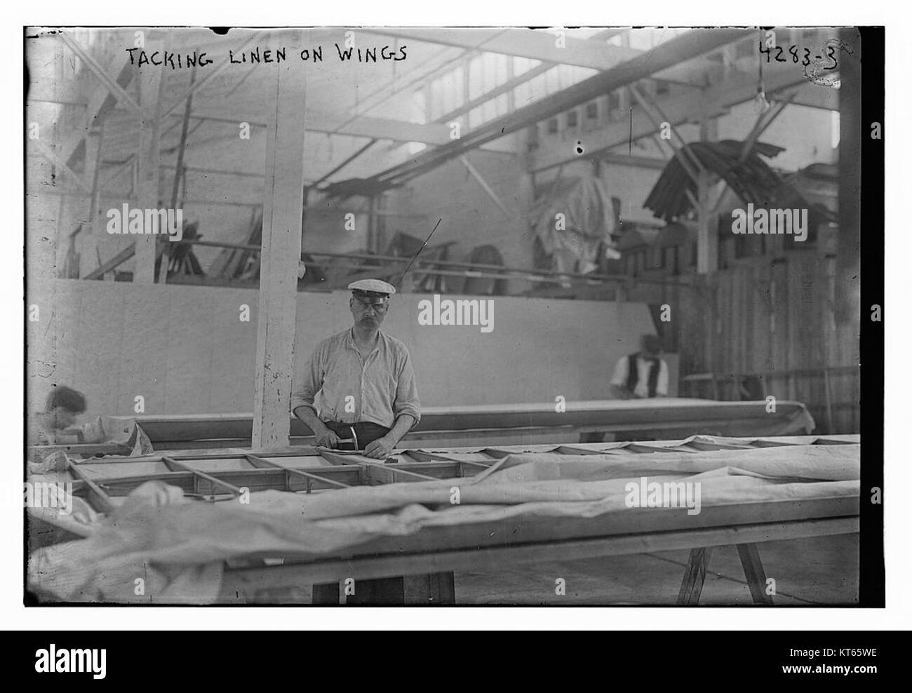 The image showcases the process of tacking linen fabric onto the wings ...