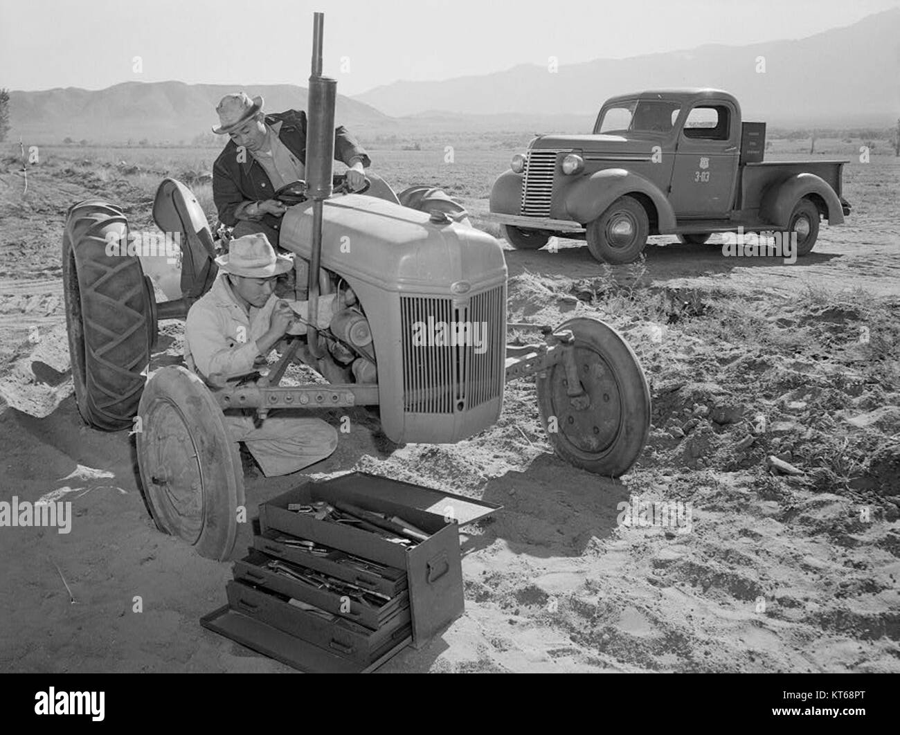 A historical photograph of a tractor repair session from 1943 ...