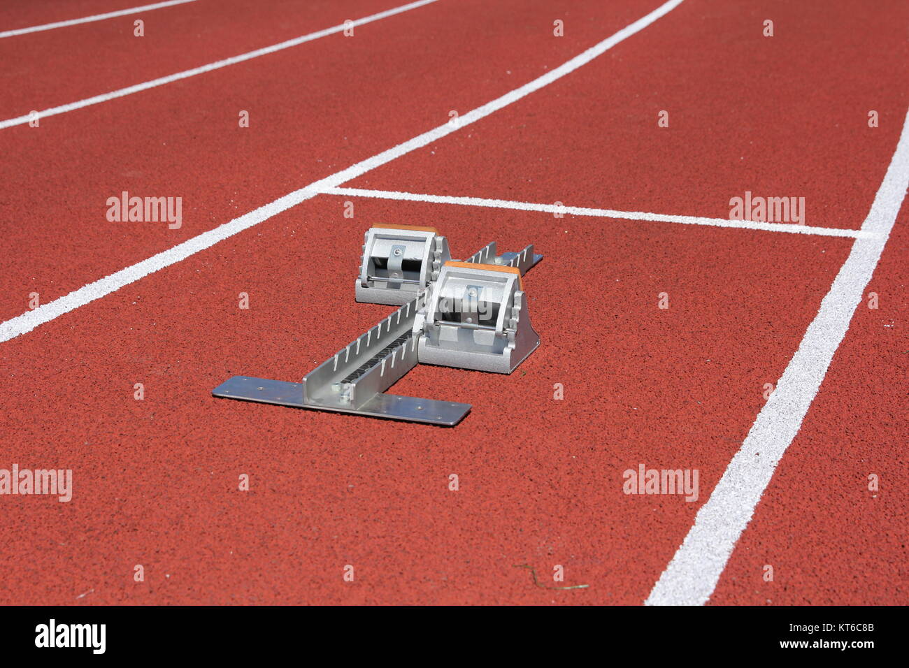 Athletics starting blocks on race red track Stock Photo - Alamy