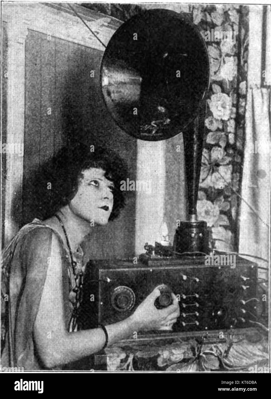 This image captures a woman tuning a radio in 1923, reflecting the ...
