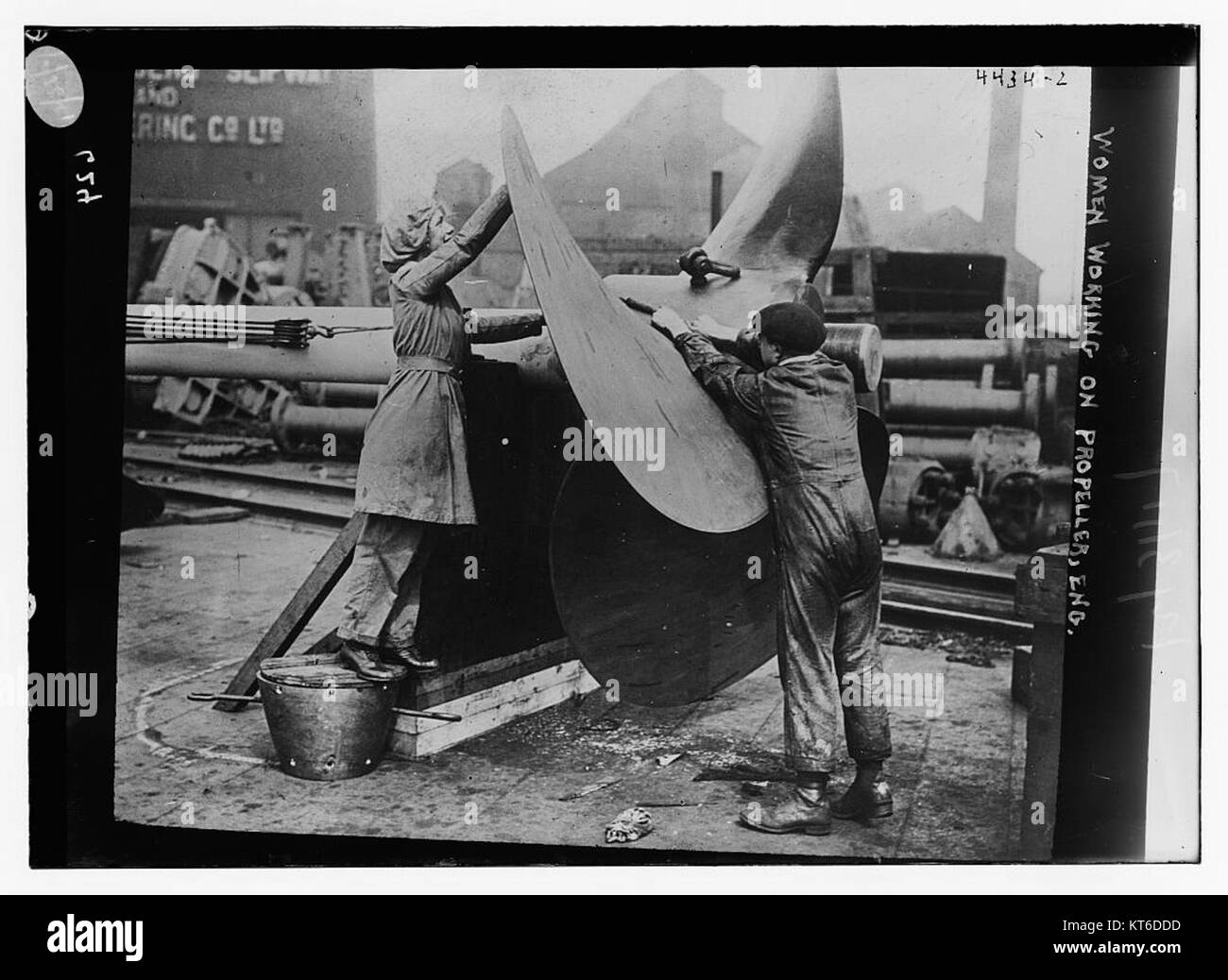 The image depicts women working on an aircraft propeller in England ...