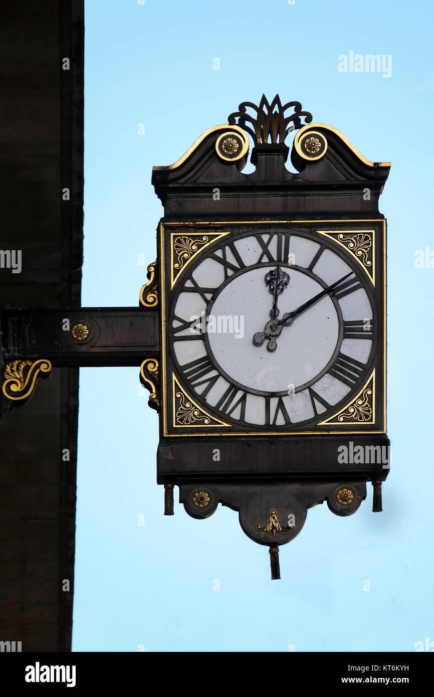 Vintage public clock hanging from building with gold ornaments Stock ...