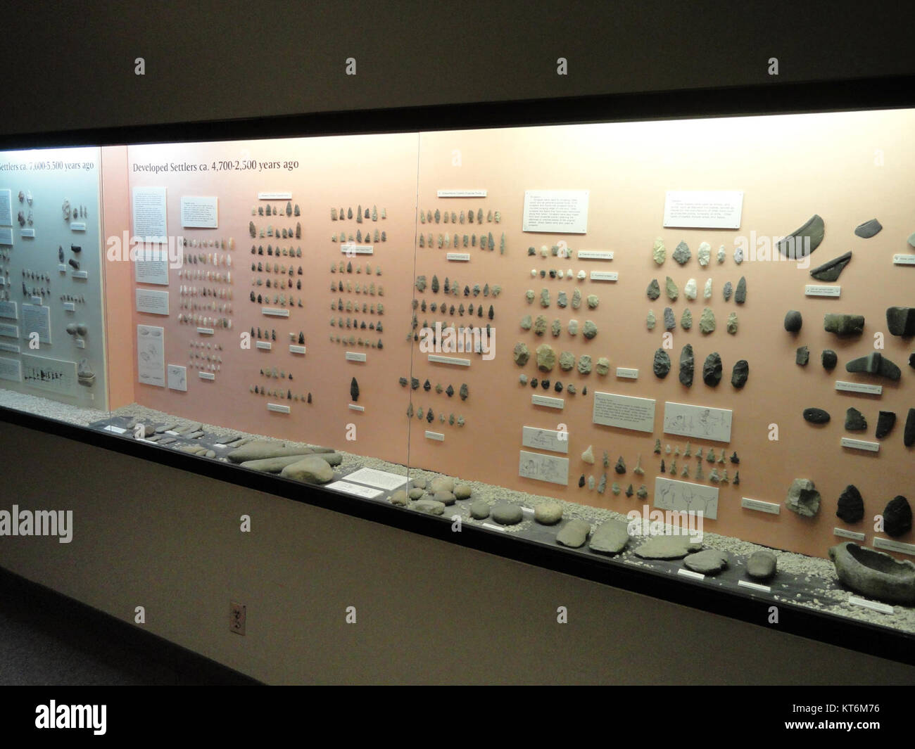 This image shows a collection of arrowheads and stone tools displayed ...