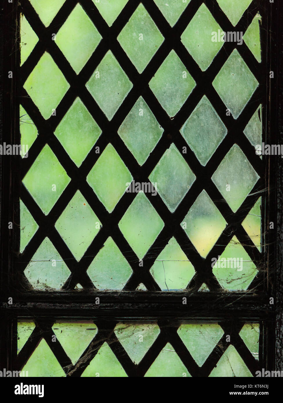 Green stained glass window with regular block pattern as background ...