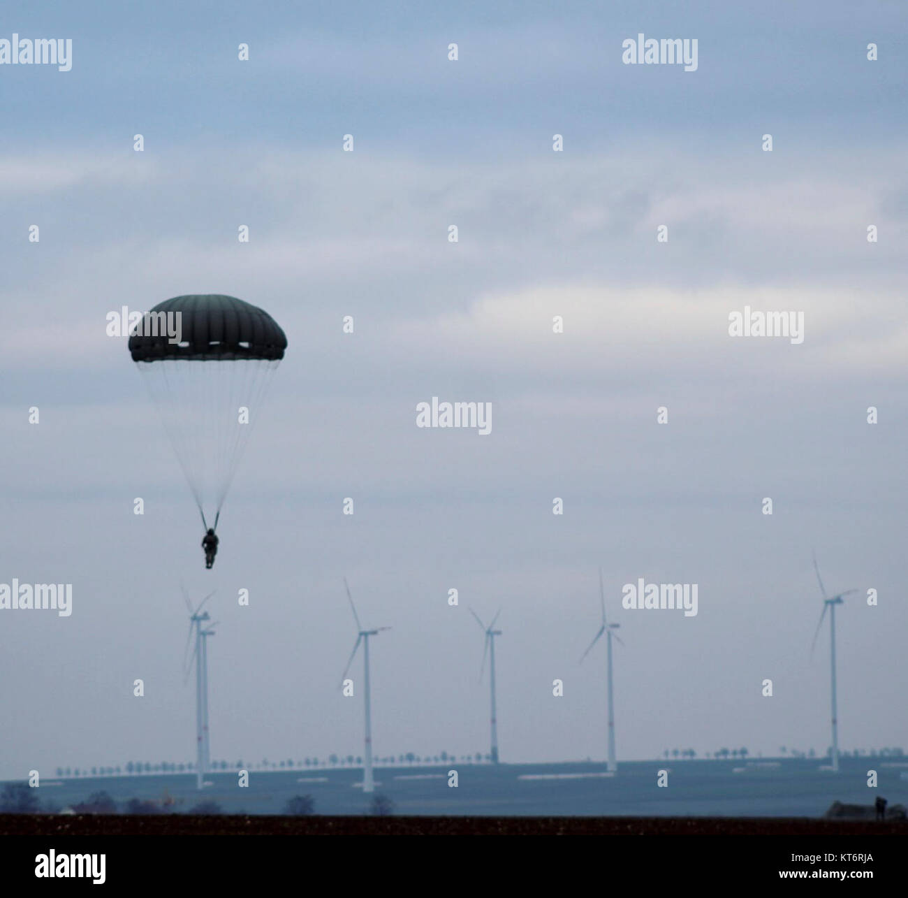 A paratrooper drifts down to the ground after successfully completing a ...