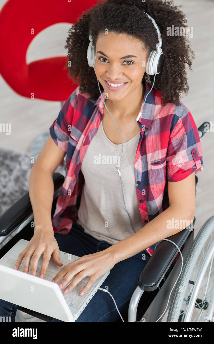 confident disabled woman using laptop at desk in creative office Stock ...