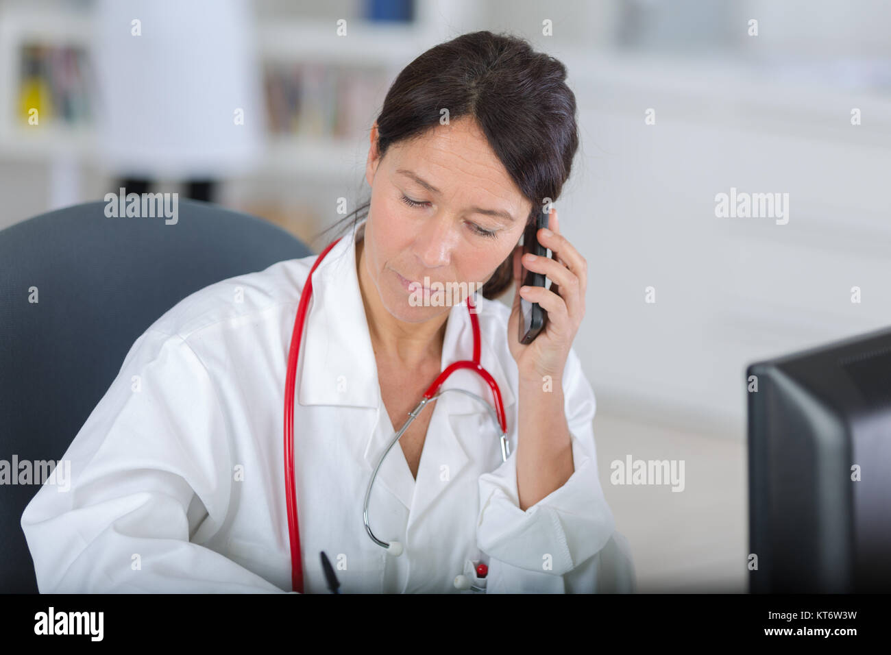 good looking female doctor on the phone in her office Stock Photo - Alamy