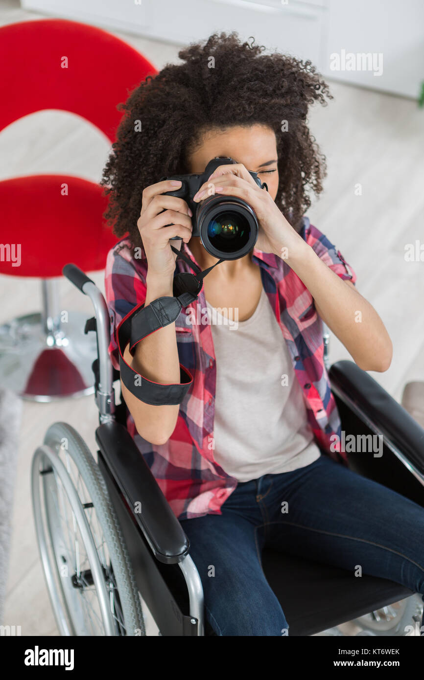 joyful woman on a wheelchair using a camera Stock Photo - Alamy