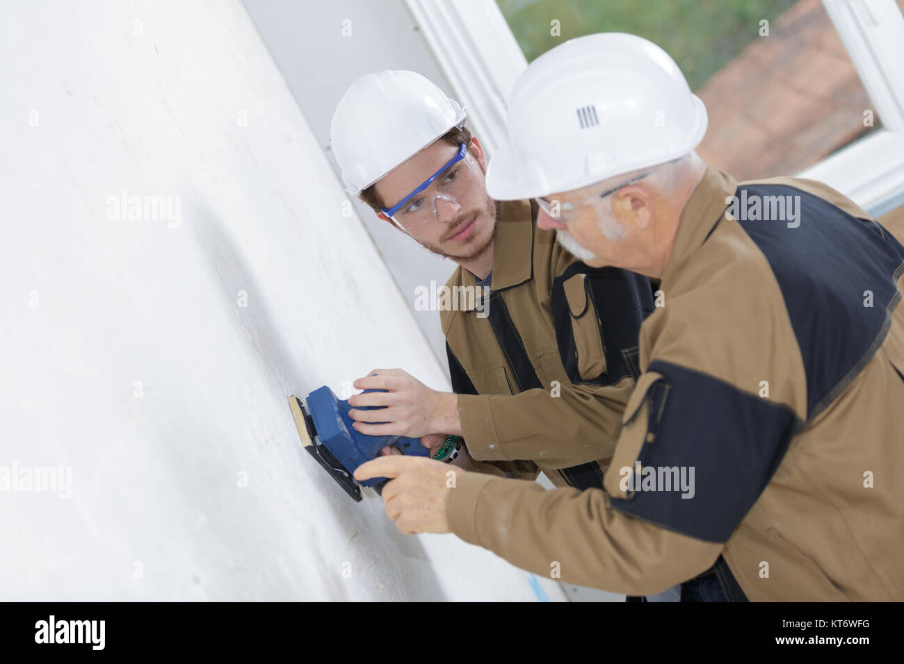 young plasterer working on indoor wall Stock Photo - Alamy