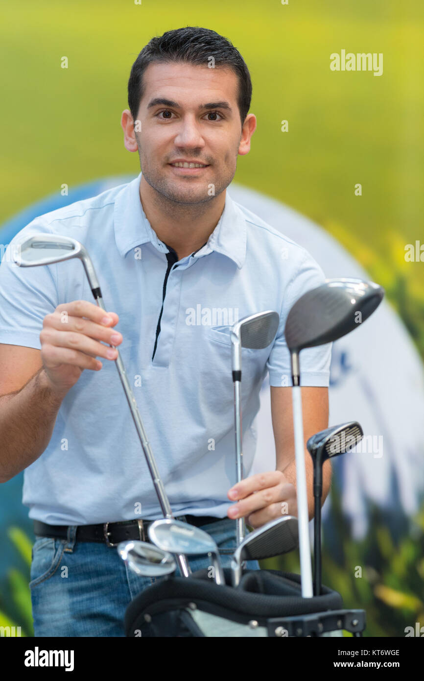 choosing golf club on retail shop background Stock Photo - Alamy