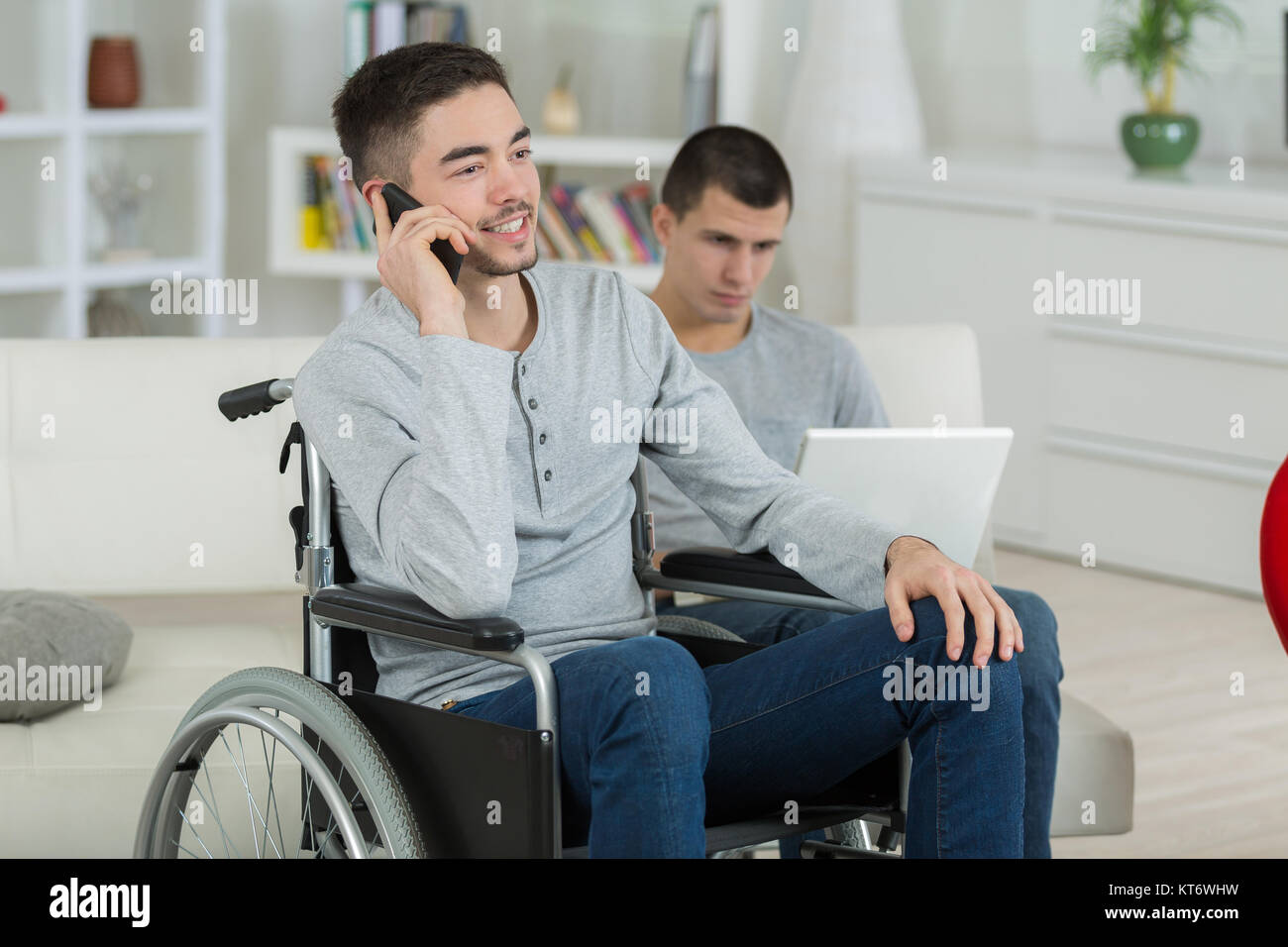 disabled young man talking on the phone at home Stock Photo - Alamy