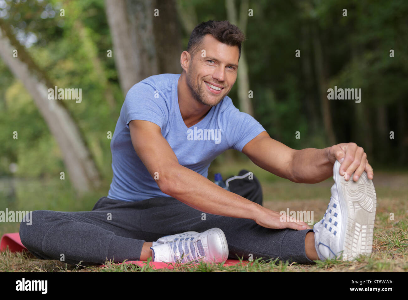 man stretching out muscles in park Stock Photo - Alamy
