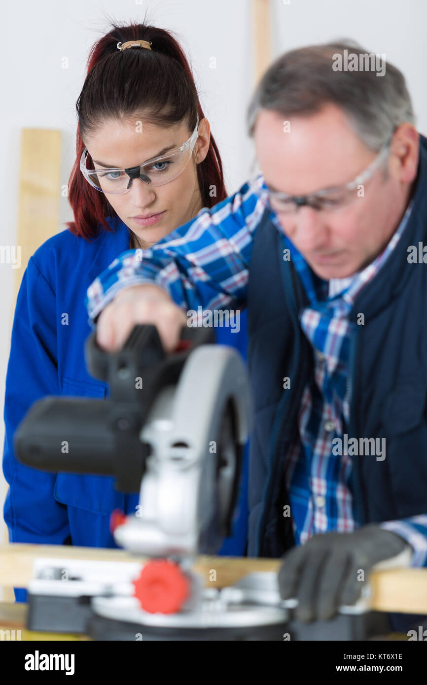 demonstrating how to use the drop saw Stock Photo - Alamy
