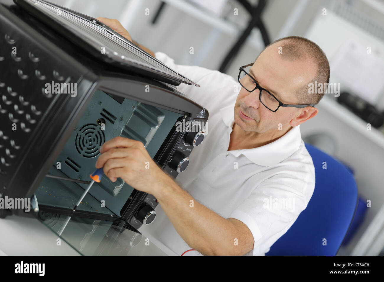 young male technician repairing oven Stock Photo - Alamy