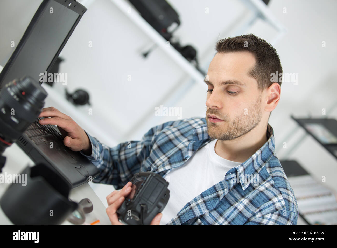photographer checking photos in camera at desk in office Stock Photo ...