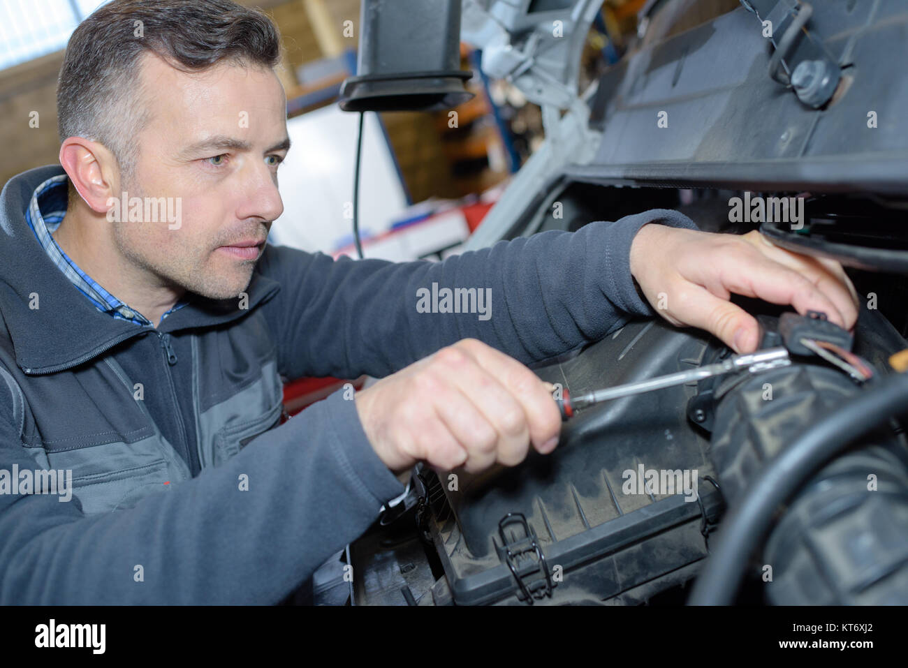 mechanic working on an engine at the repair garage Stock Photo - Alamy